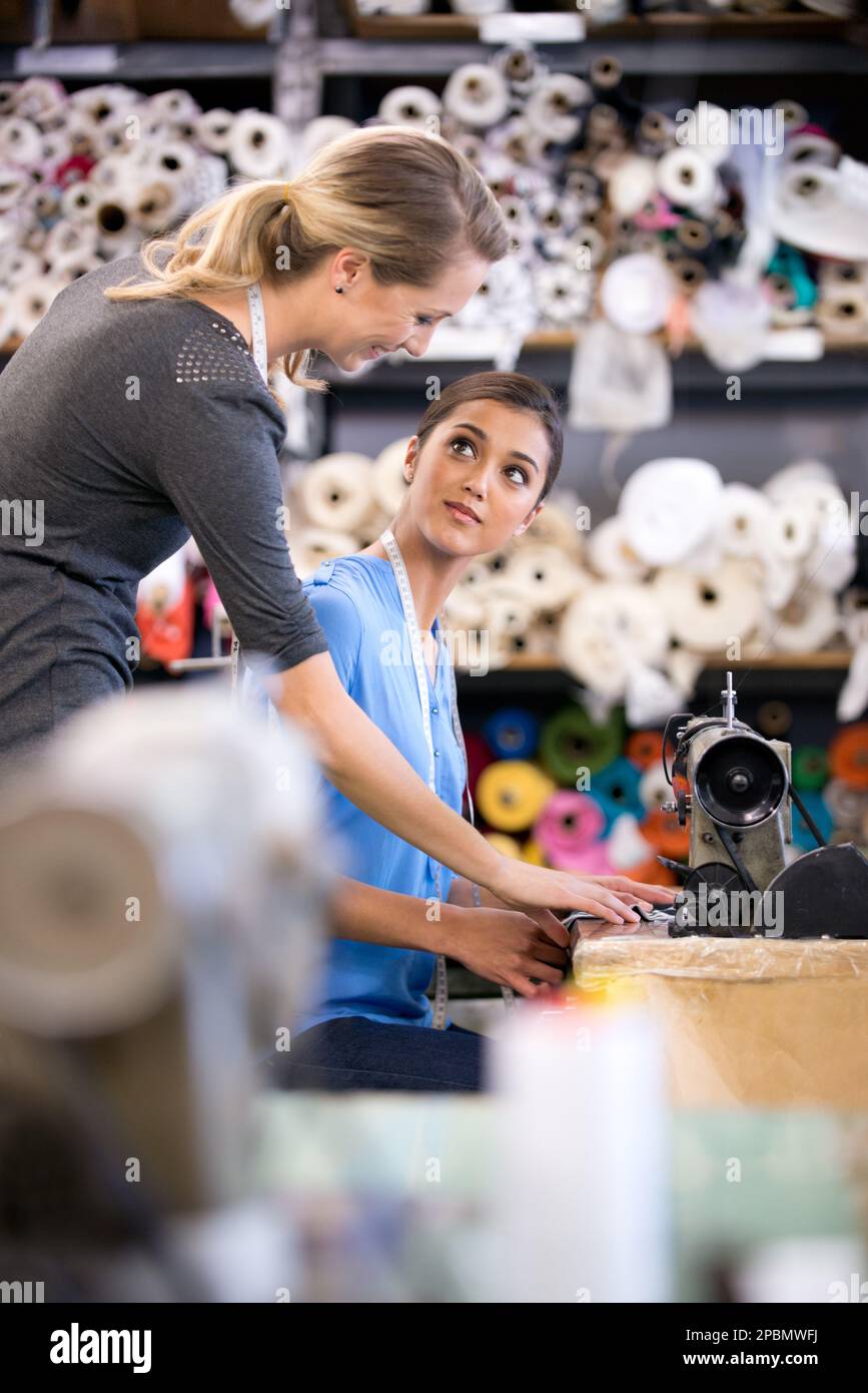 Giving each other some sewing tips. Two seamstresses working together ...