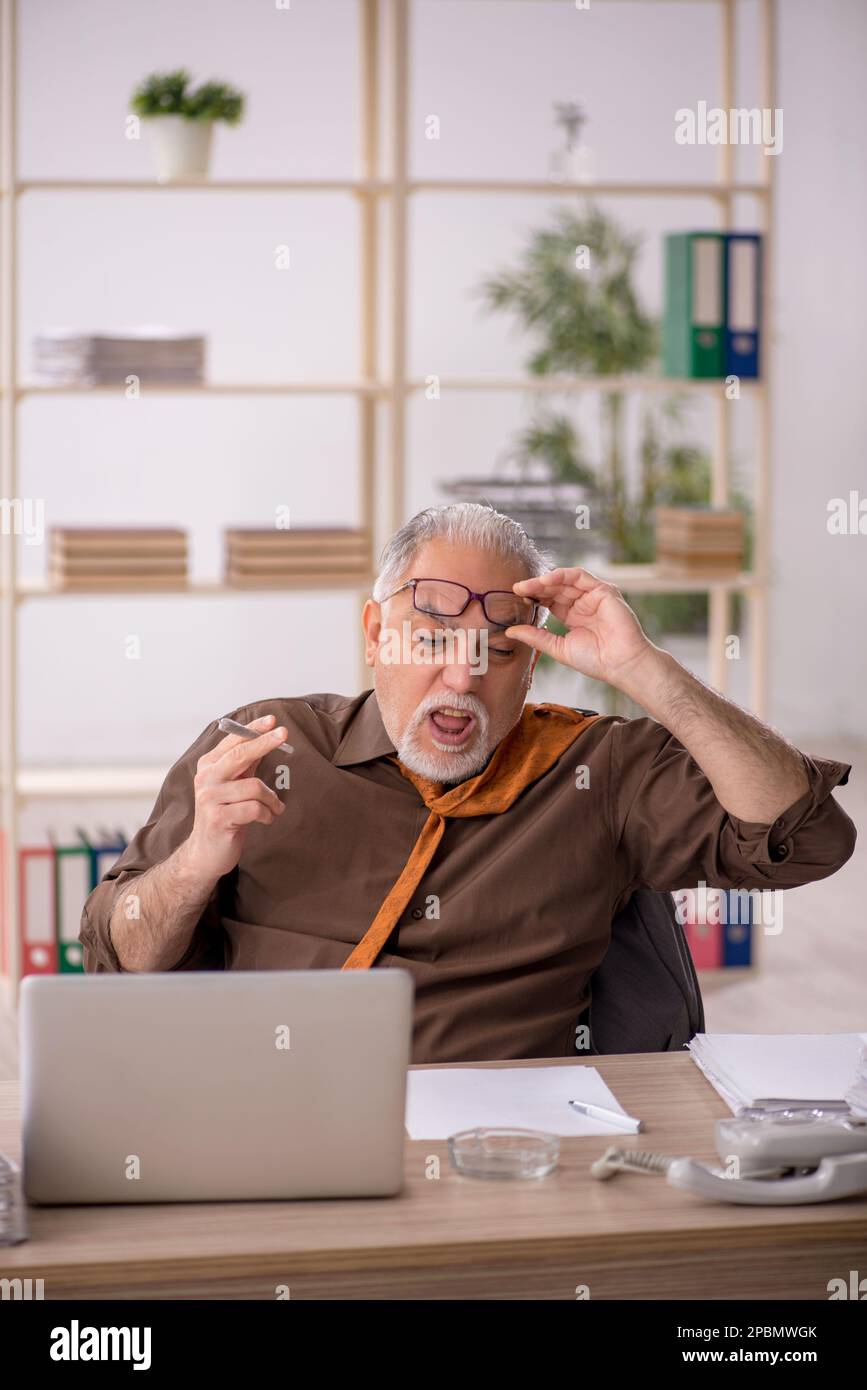 Old businessman employee smoking cigarette at workplace Stock Photo - Alamy
