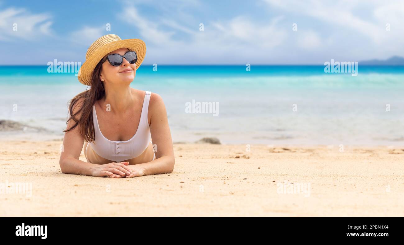 Woman Lying On The Sea Beach Enjoying And Relaxing In Summer Stock