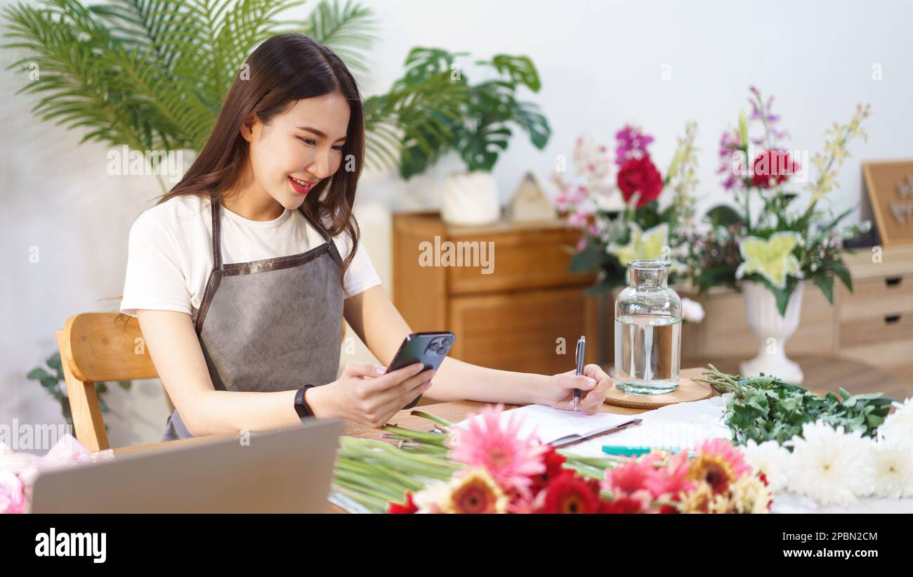 Flower shop concept, Female florist checking flower orders on ...