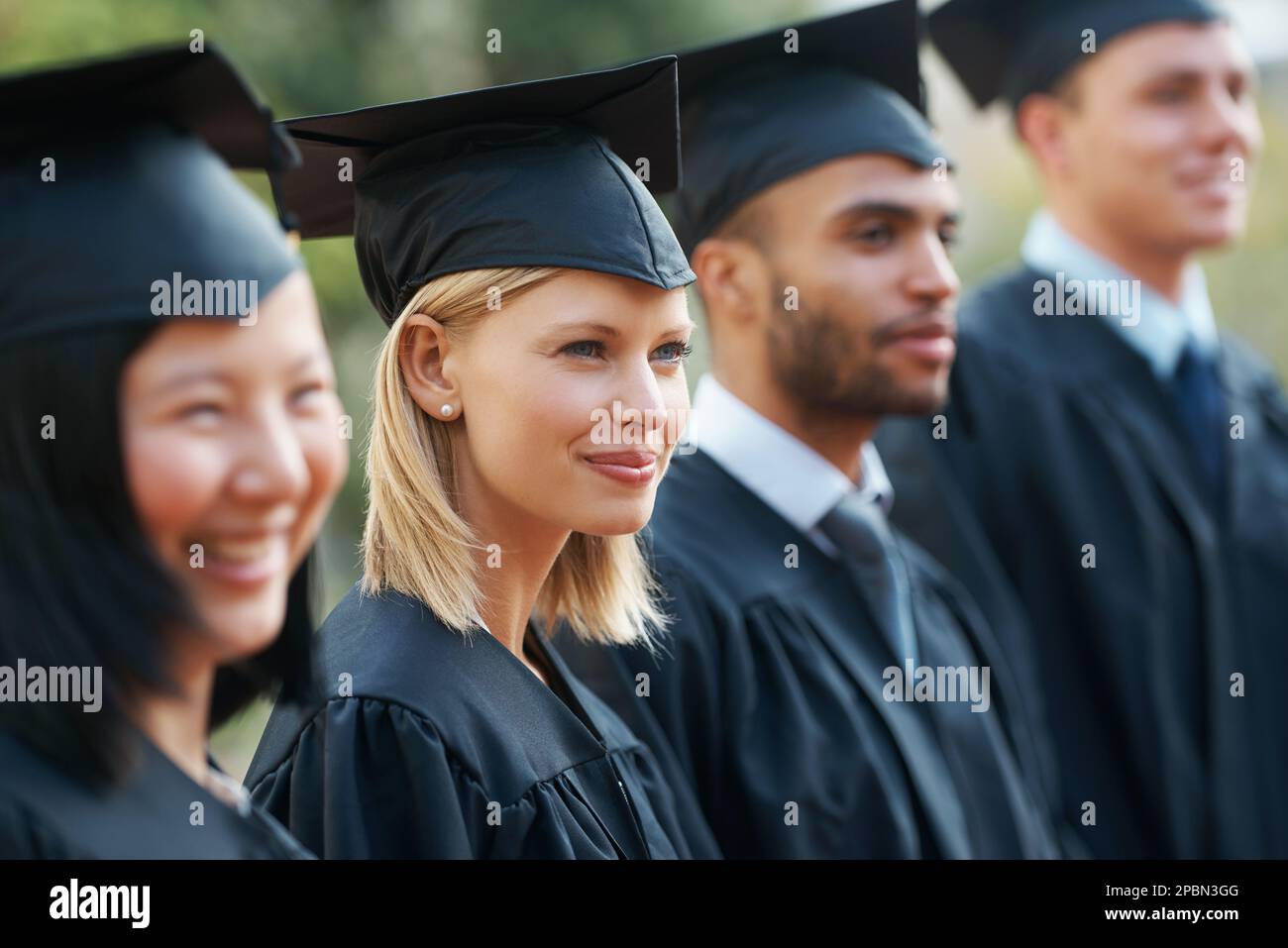 Facing their future. Young college graduates holding their diplomas ...
