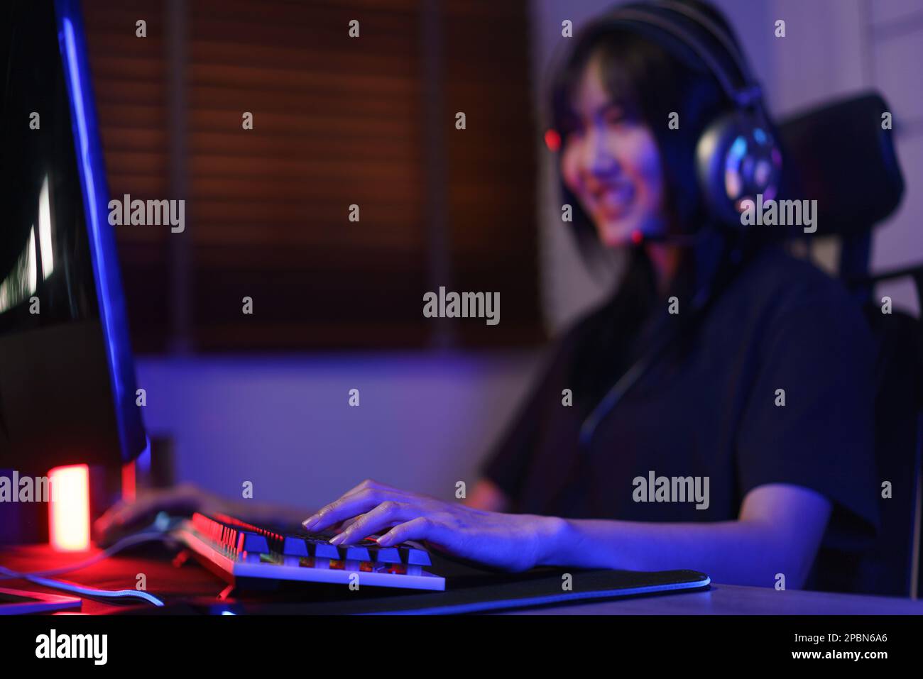 Female cyber hacker gamer in headphone serious face to playing games or ...