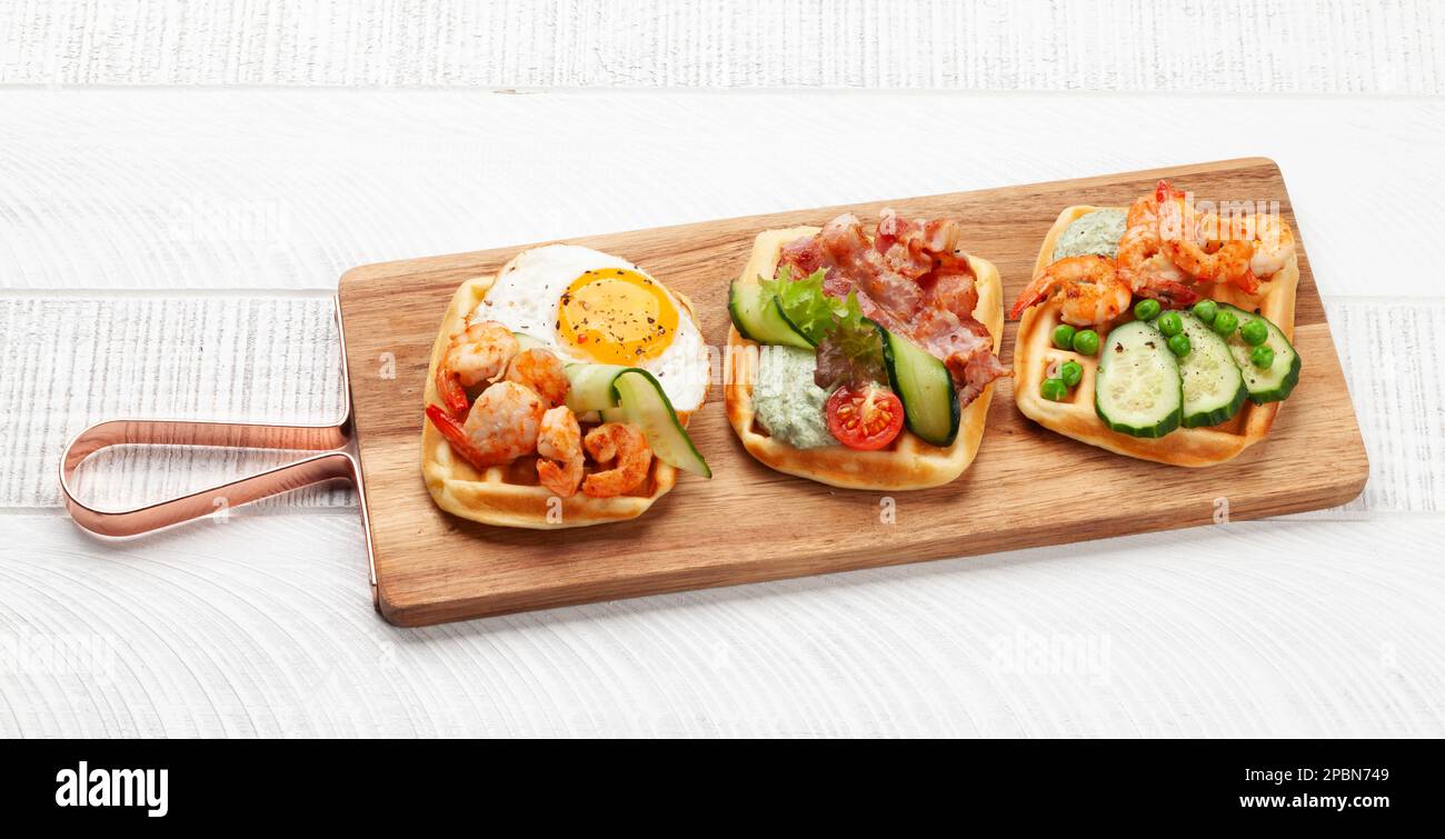 Breakfast waffles with fried eggs, salmon, bacon, cucumber and prawns ...