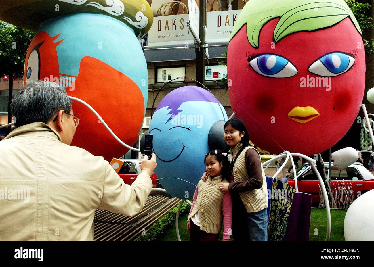 Hong Kong shoppers take pictures of giant Easter eggs on display at a shopping mall in Hong Kong ...