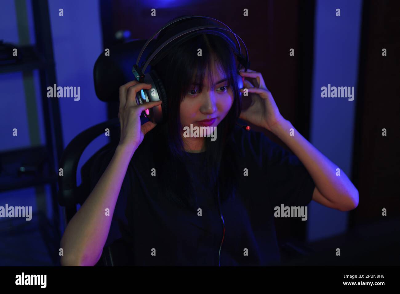 Female cyber hacker gamer in headphone watching video game on monitor ...