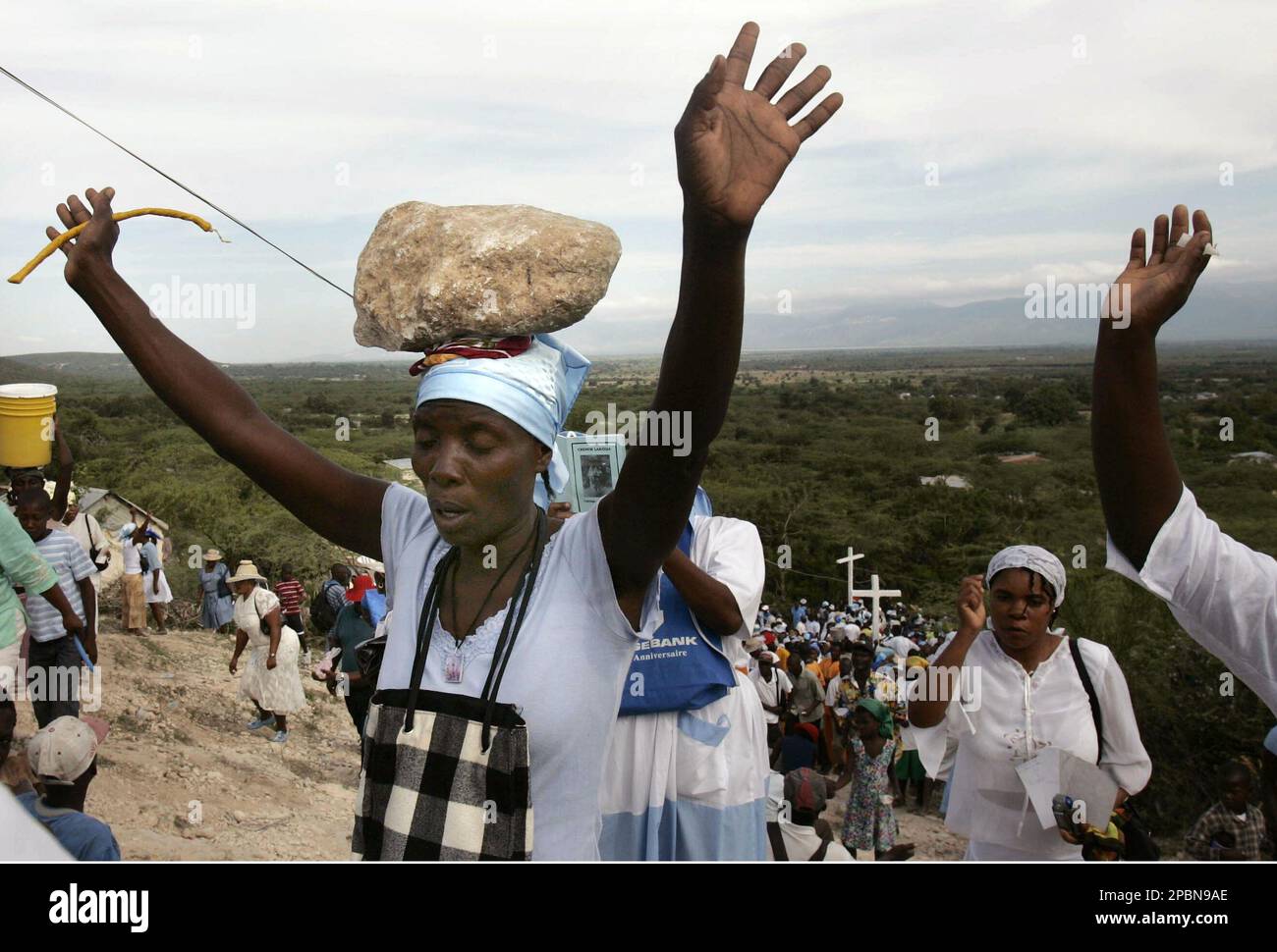 A woman prays as she carries a stone on her head during a pilgrimage to ...