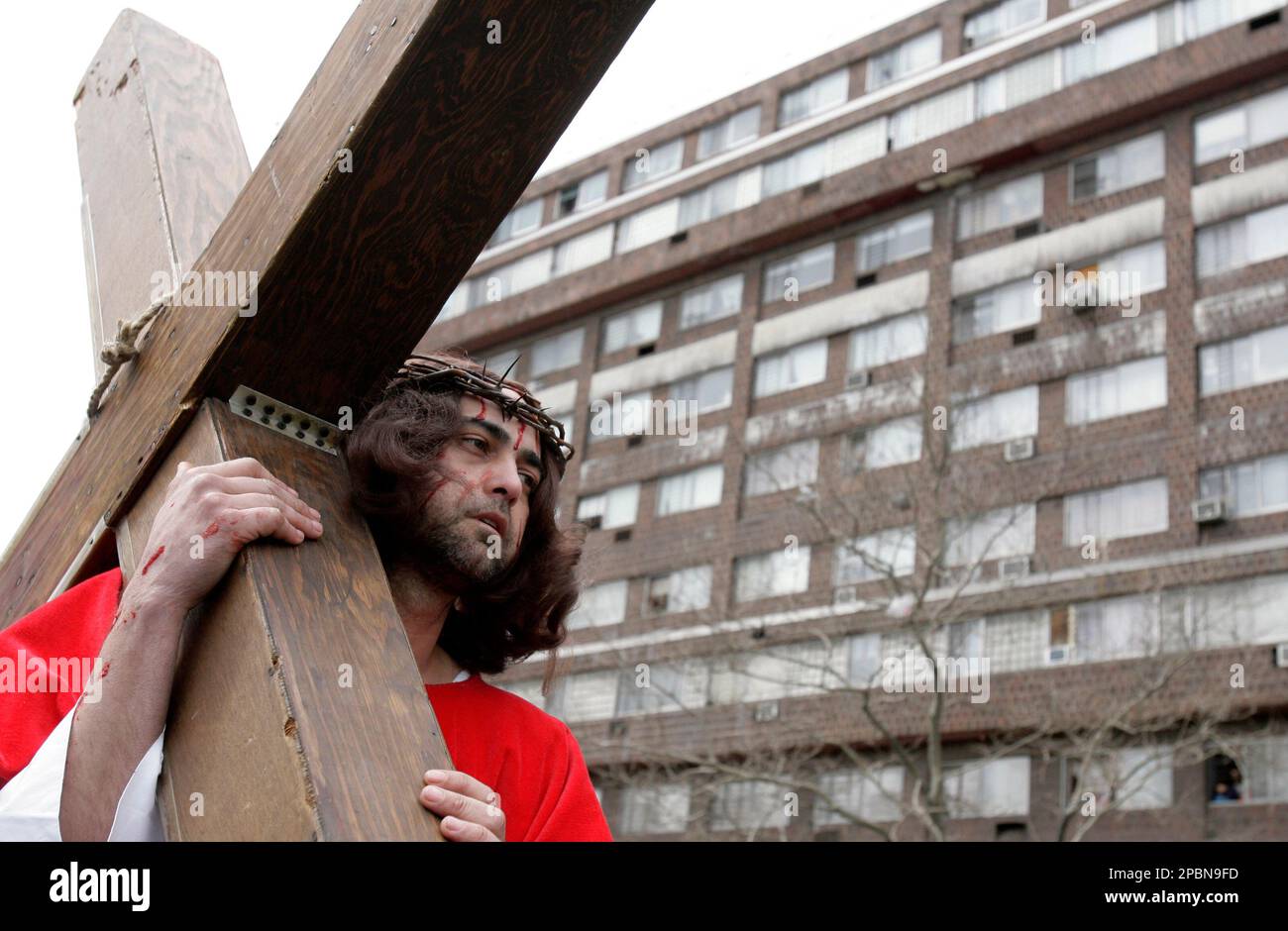Jesus Christ, played by Rafael N. Gonzalez, drags a cross through the ...
