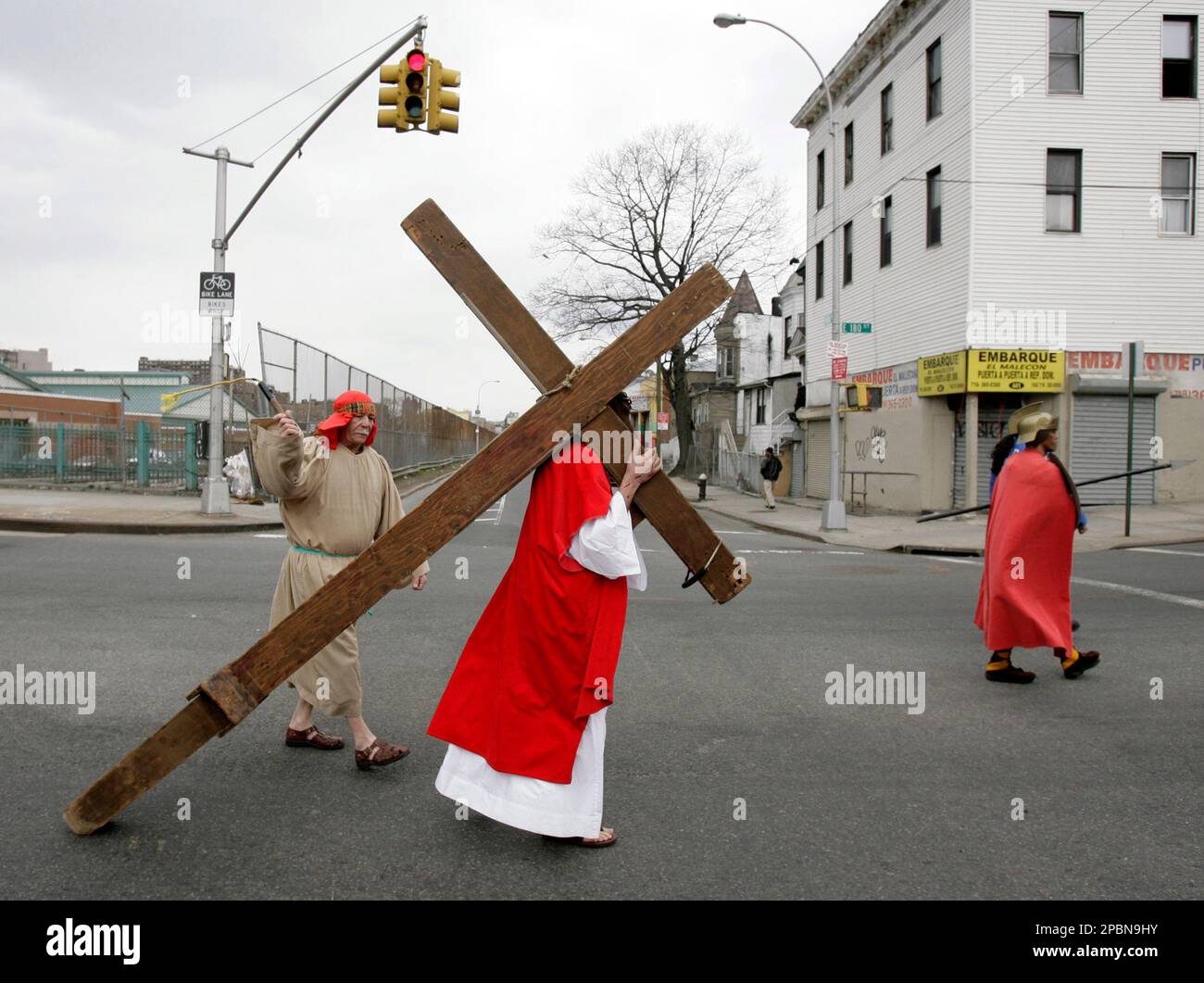 Jesus Christ, played by Rafael N. Gonzalez, center, drags a cross ...
