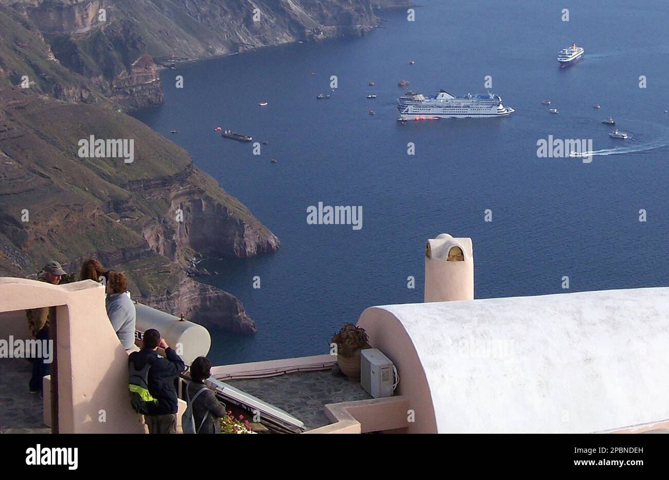 Residents look at the listing cruise ship 'Sea Diamond' carrying nearly ...