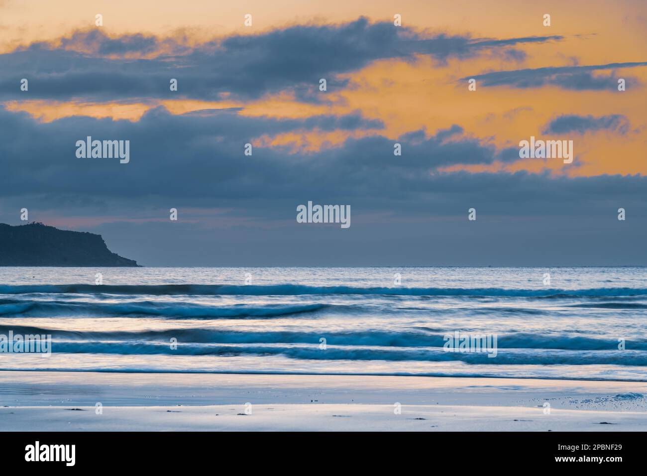 Subtle summer sunrise with rain clouds in the distance at Umina Beach ...