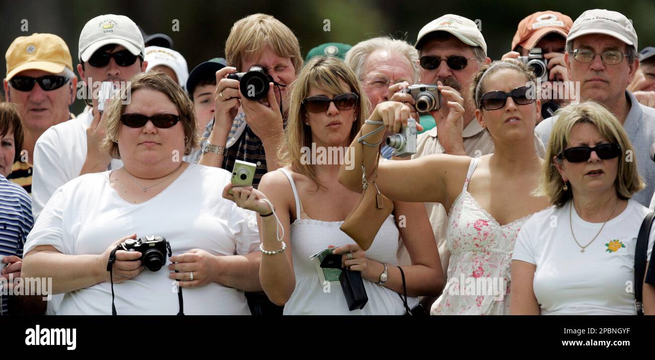Patrons take pictures near the practice green during practice for the ...