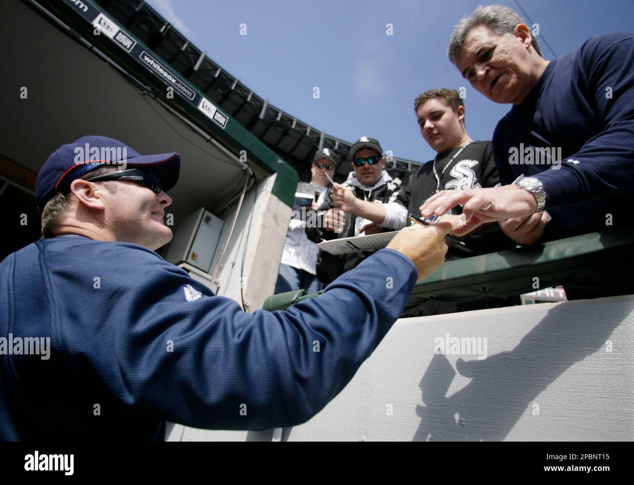 Cleveland Indians manager Eric Wedge, left, signs autographs before a ...