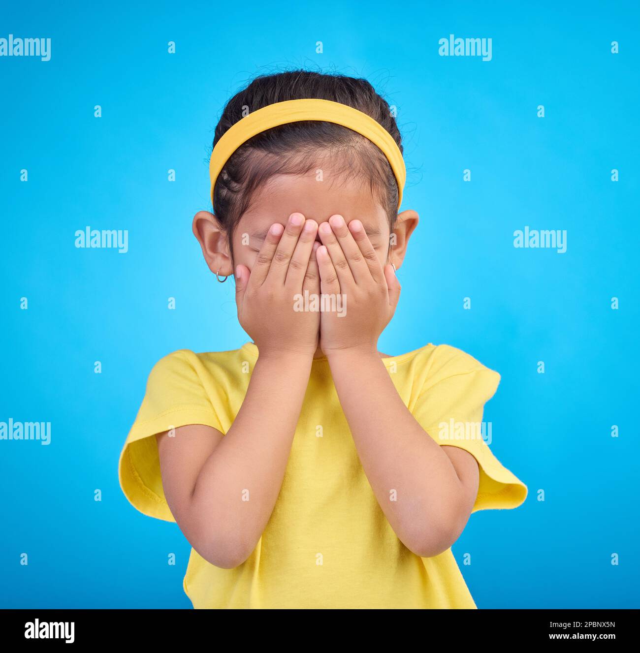 Cover eyes, hands on face and child on blue background for shy, mistake ...
