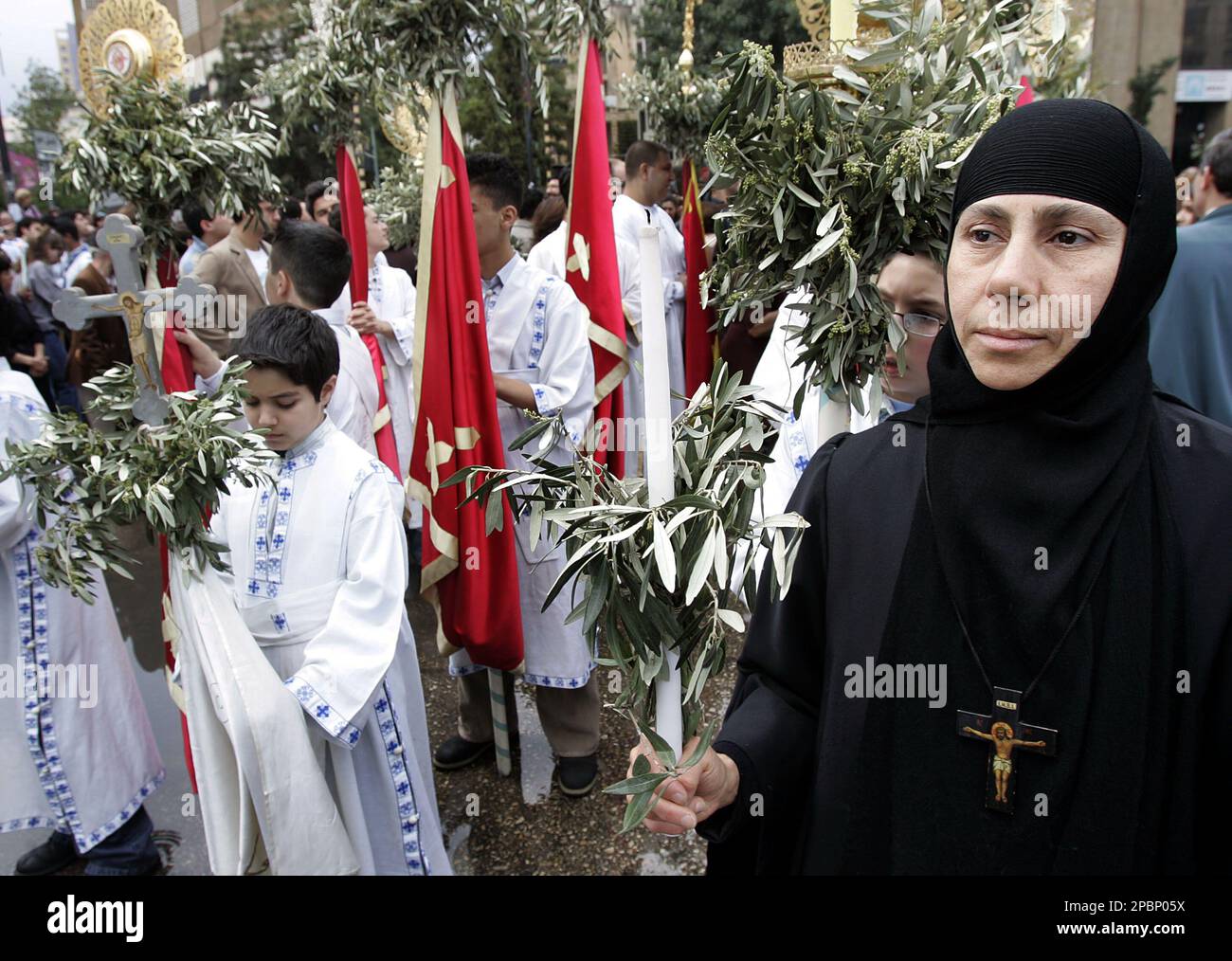 A Lebanese Christian nun holds a candle, as she walks with other ...