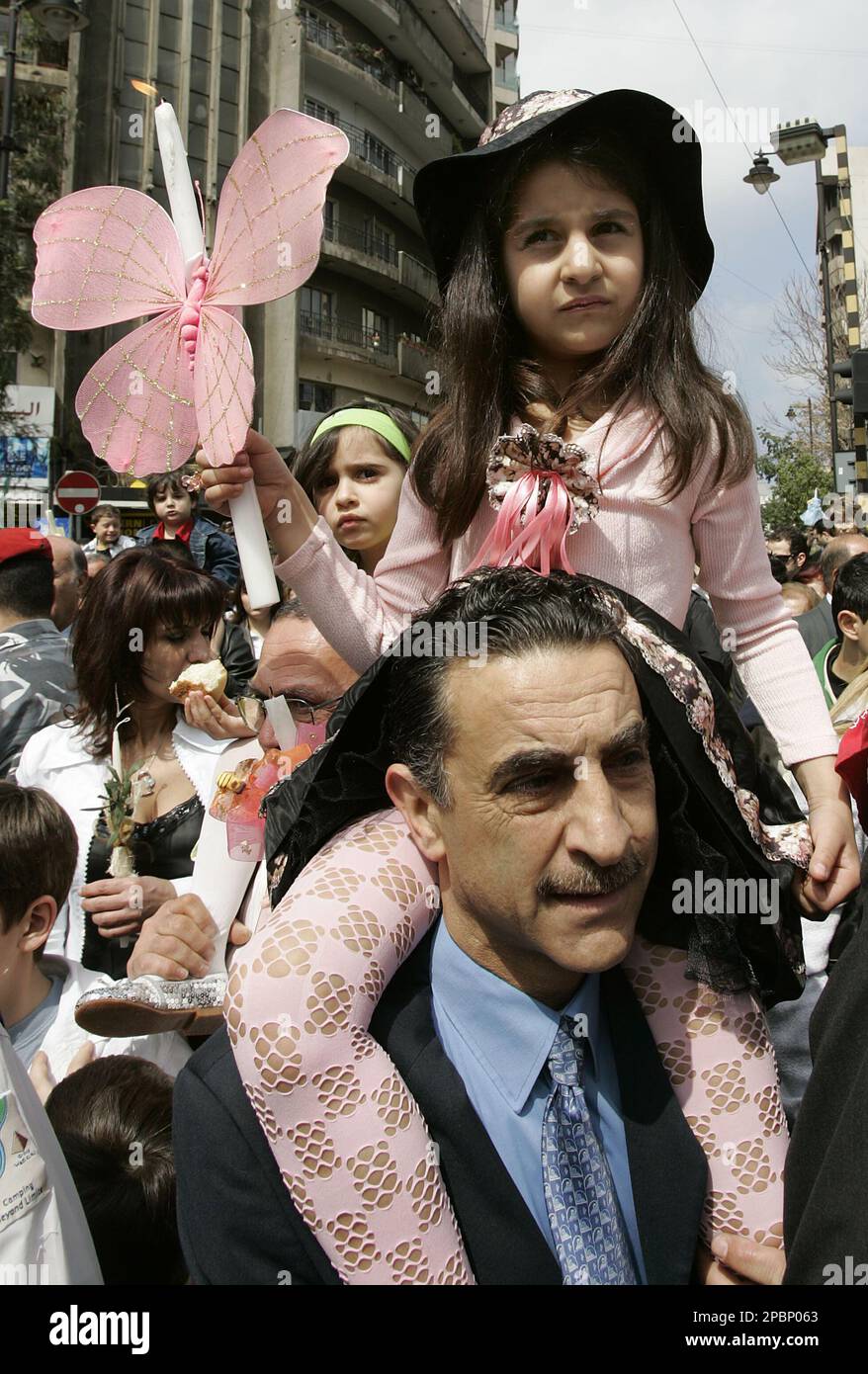Lebanese Christian man, carries his daughter on his shoulders as she ...