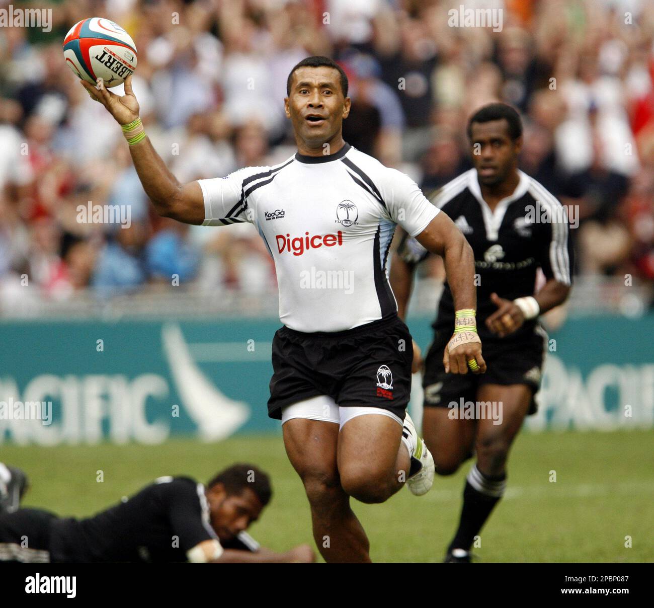 Fiji's Waisale Serevi holds the ball as he runs for the last try ...