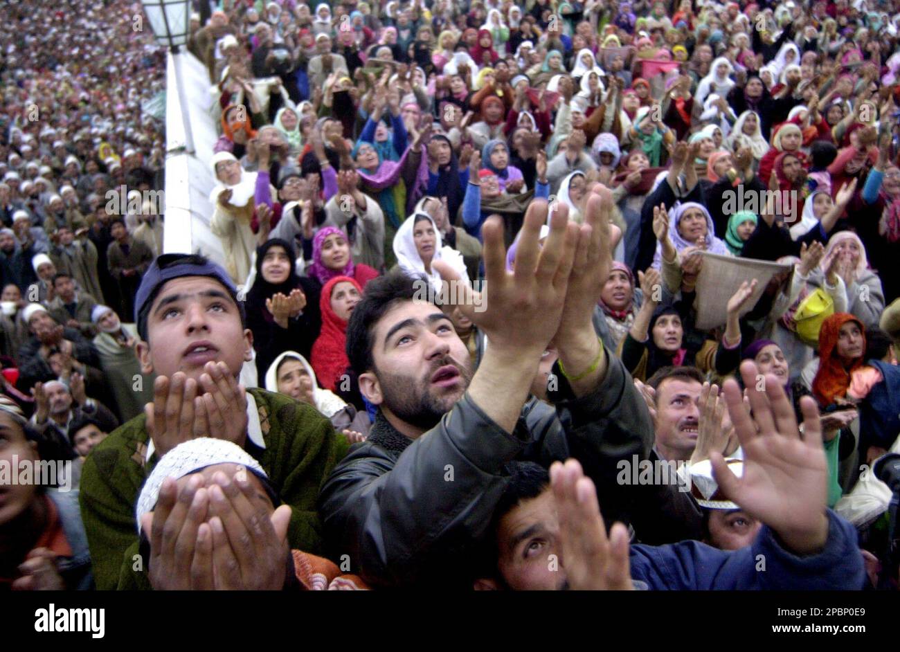 Kashmiri Muslims raise their hands for prayers as head priest displays ...