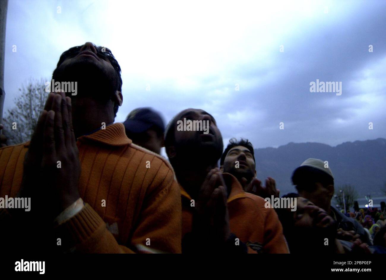 Kashmiri Muslims raise their hands for prayers as head priest displays ...