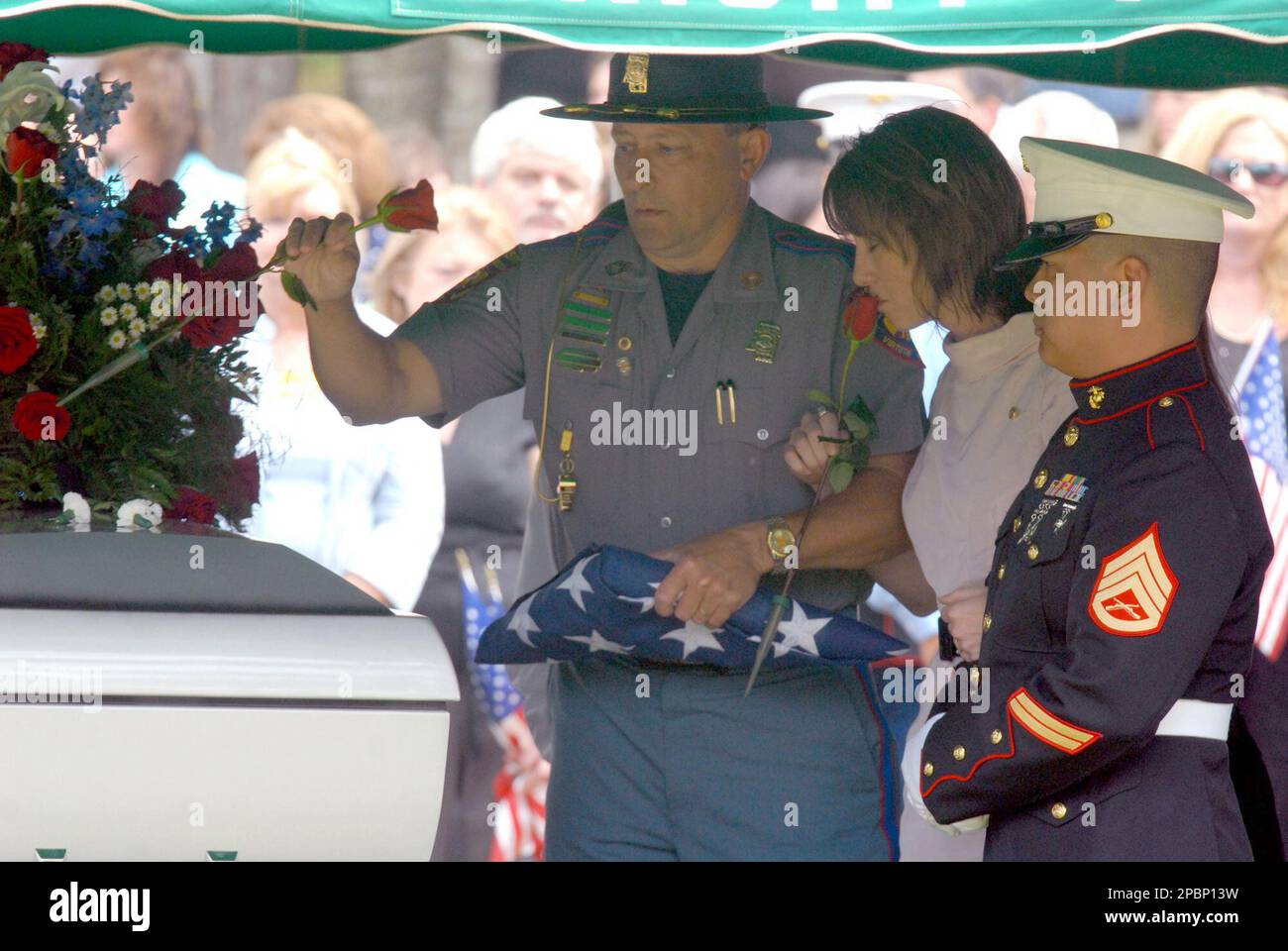 Jerome Lee, father of Cpl. Dustin Lee, places a rose on his son's ...