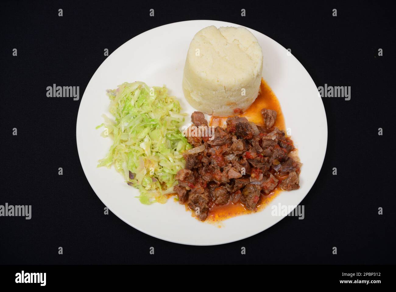 beef stew served with African ugali and fried cabbage Stock Photo - Alamy