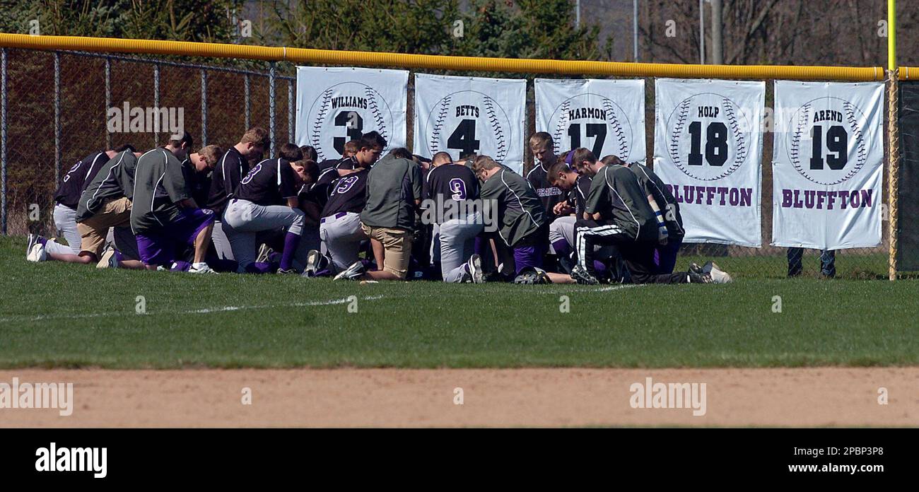 Members of Bluffton University's baseball team gather in prayer before ...