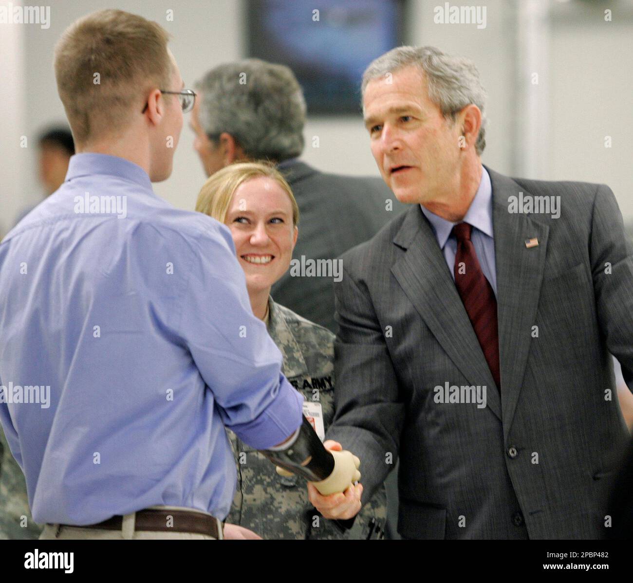 President Bush, right, shakes hands with the prosthetic arm of 1st Lt ...