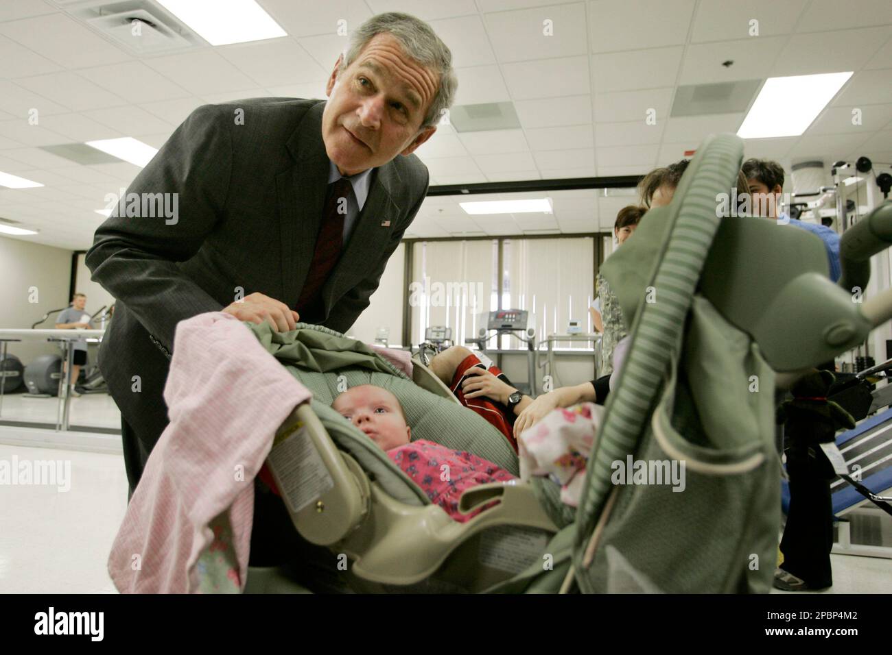 President Bush stoops down to look at two-month-old Hailey Gardner ...