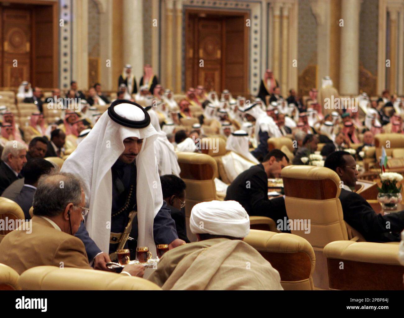 A Saudi waiter serves tea for Arab leaders during the closing session ...