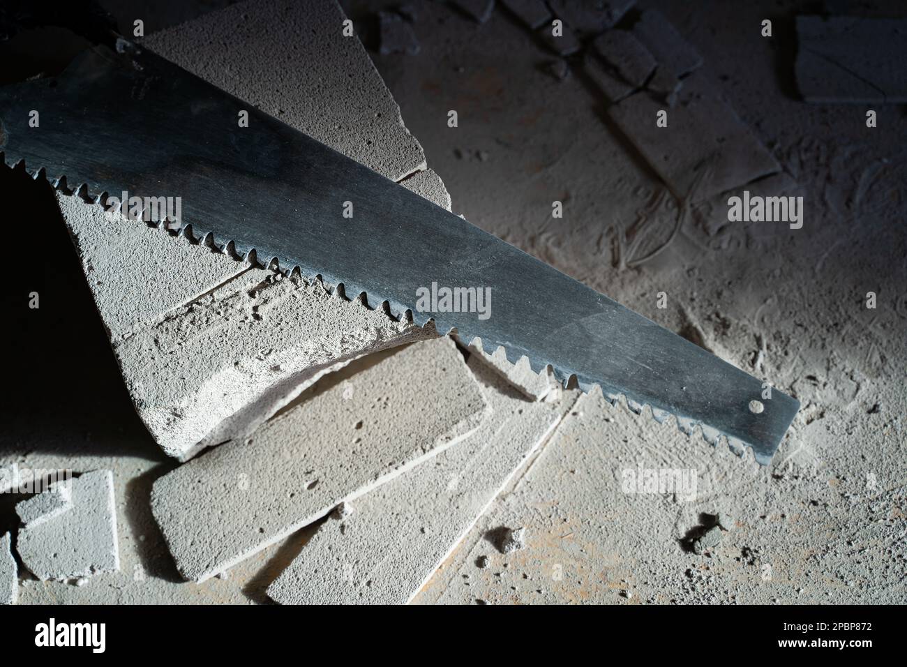 Aerated concrete hacksaw lies on an aerated concrete brick with scraps ...