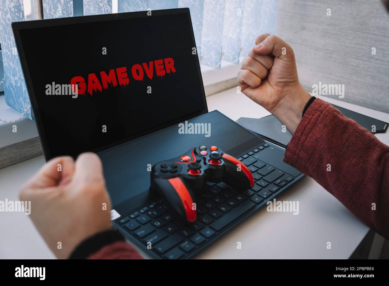 Game over on laptop screen. losing a video game. joystick on the ...