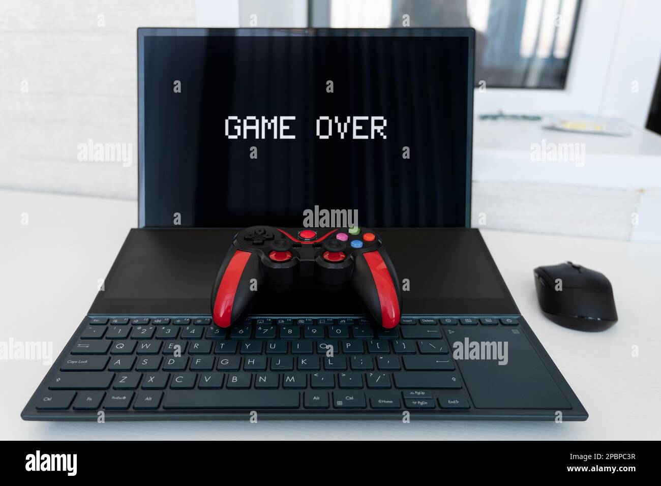 the joystick from the game console is black and red and the laptop. The ...