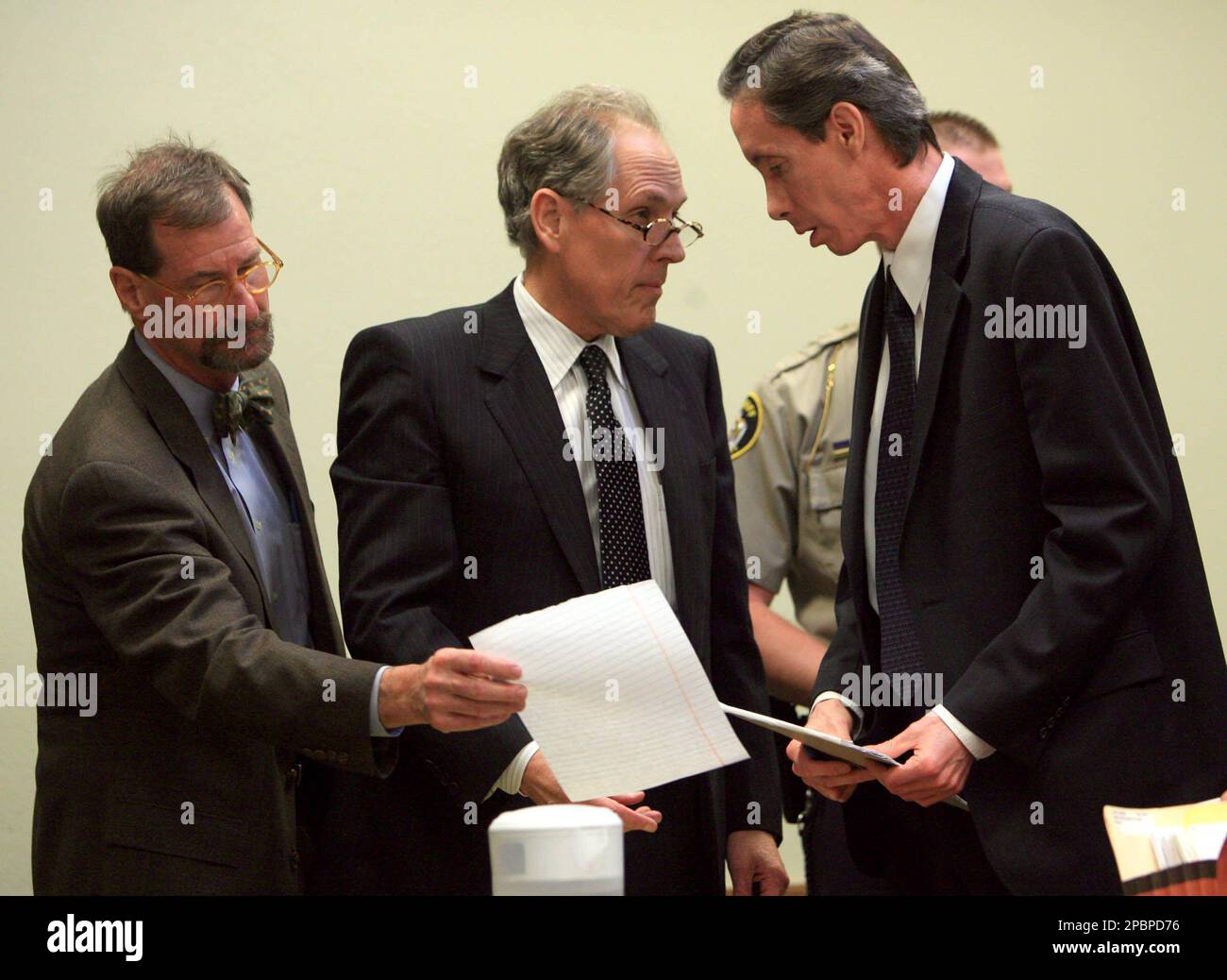 Defense attorney Walter Bugden Jr. (left) takes a paper that Warren ...