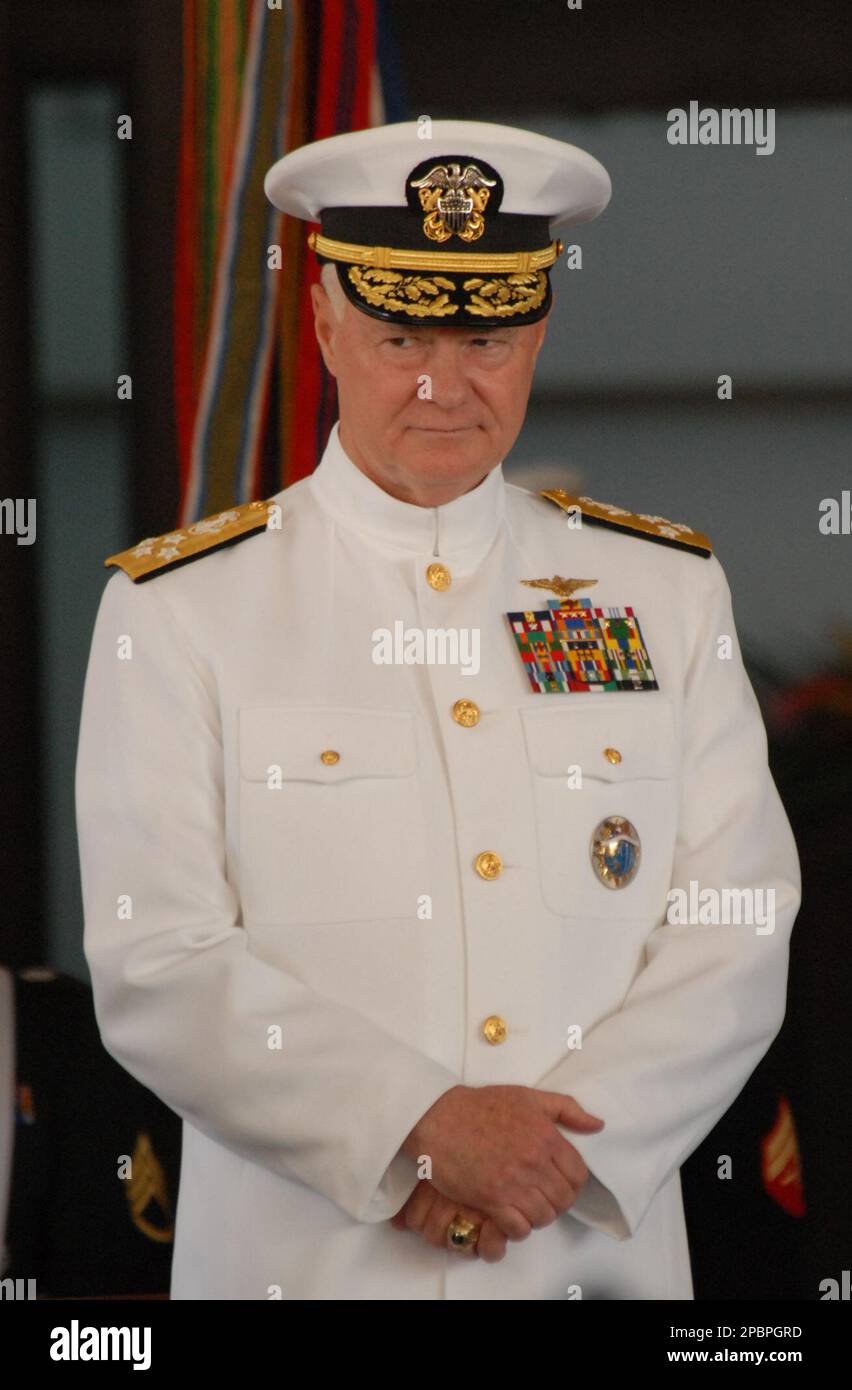 Adm. Timothy J. Keating stands and listens to other speakers during his ...