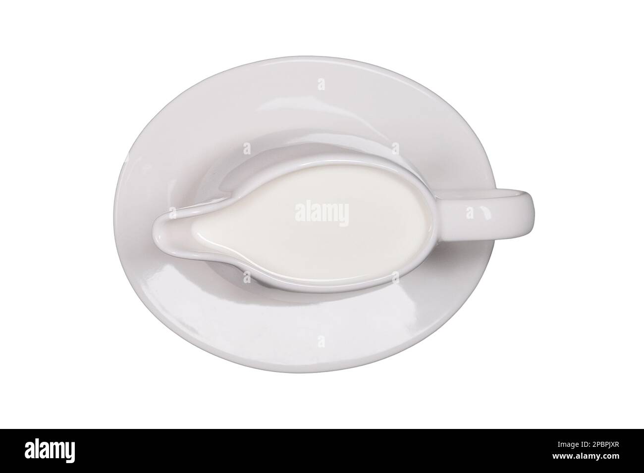 White creamer with milk on a saucer, isolated on a white background ...