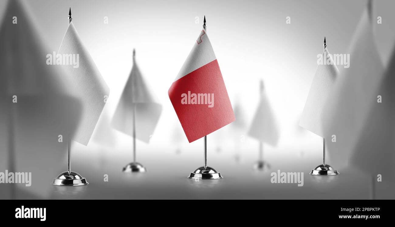 The national flag of the Malta surrounded by white flags Stock Photo ...