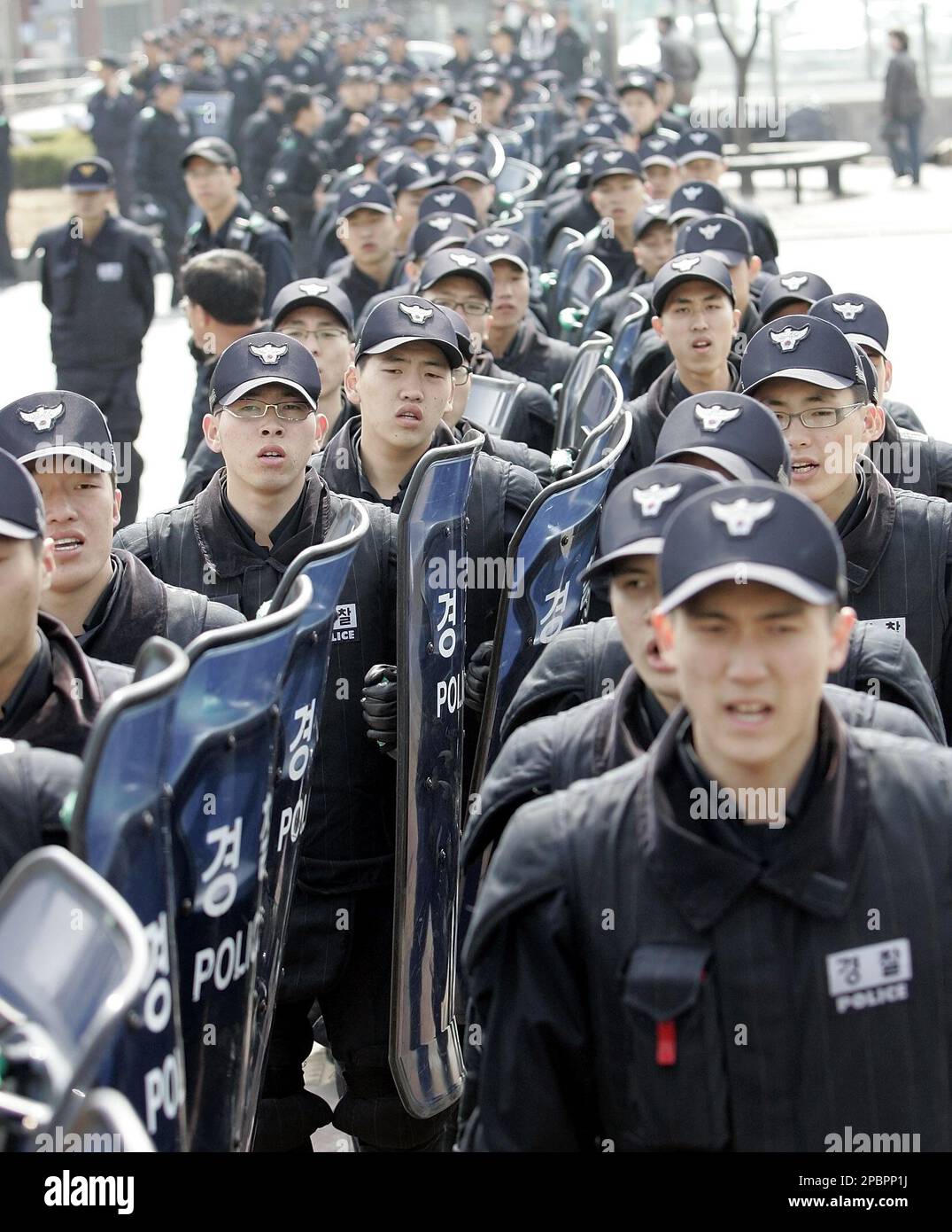 South Korean riot police officers guard while protesters march during ...