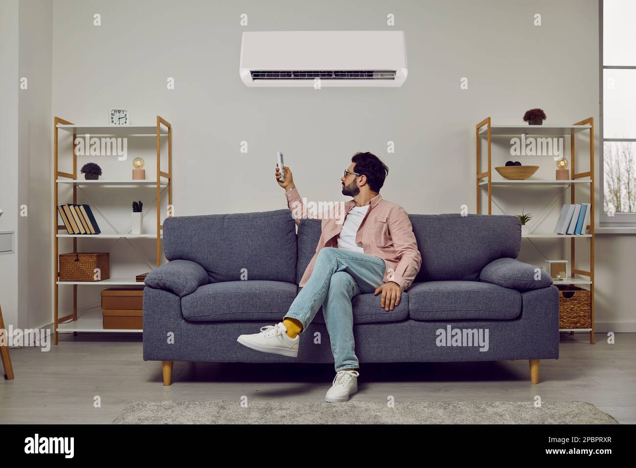 Man enjoys using newly installed air conditioner and sets comfortable ...