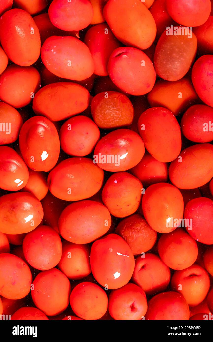 Beet flavored olives. Close-up pile of red kalamata olives Stock Photo ...