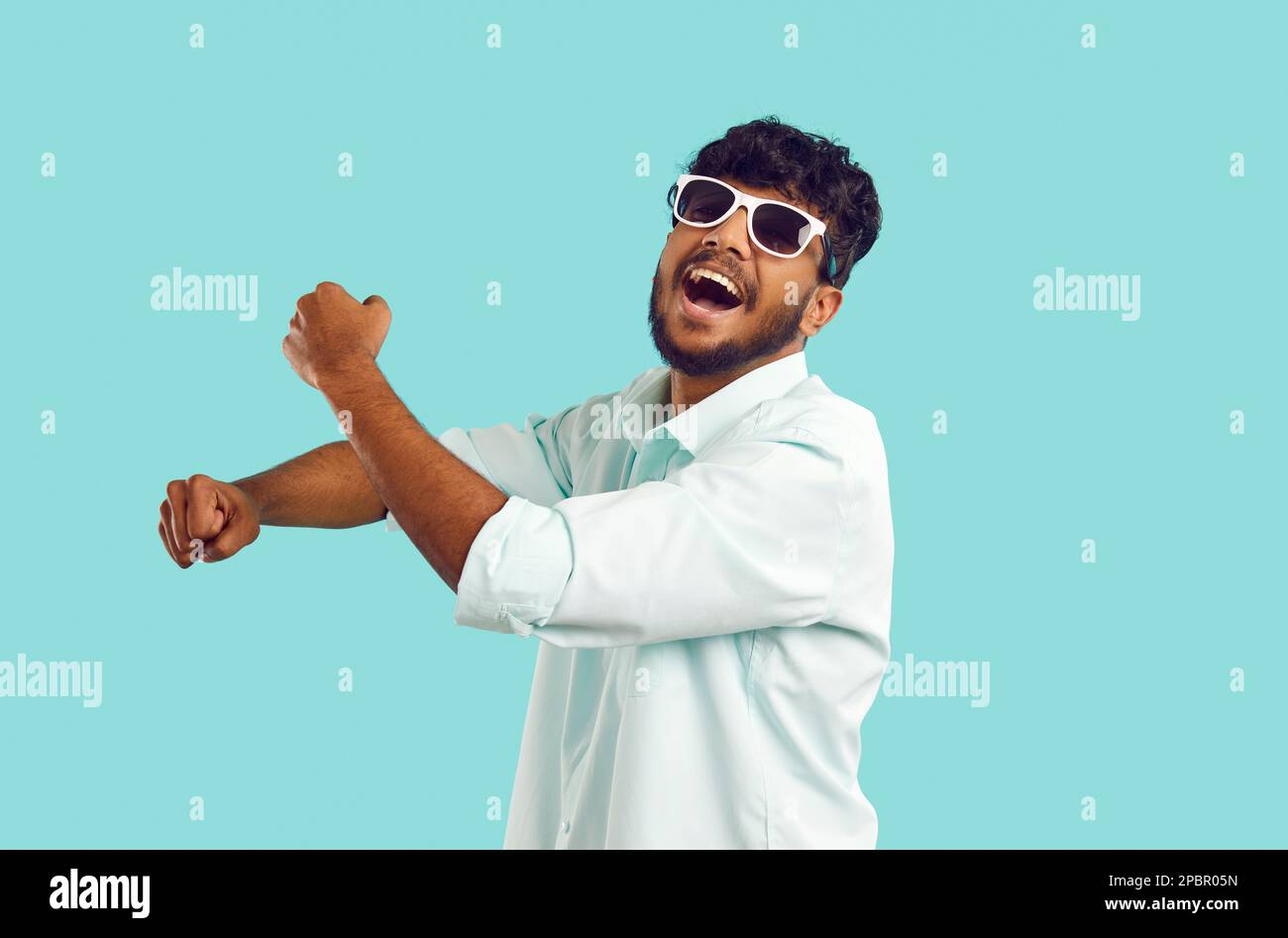 Cheerful young Indian man laughing, singing, having fun and dancing ...