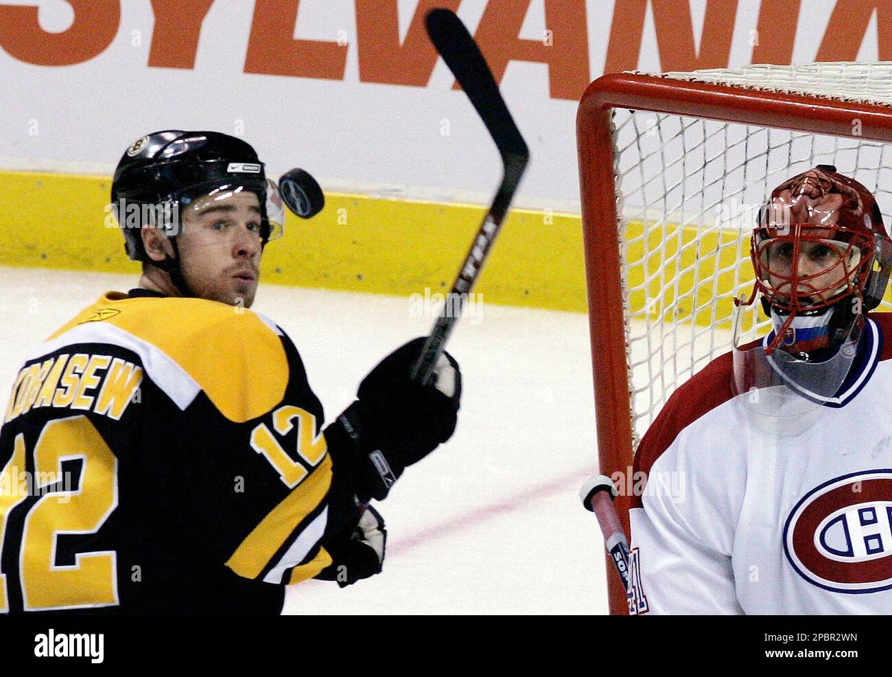 Boston Bruins' Chuck Kobasew, left, keeps eyes on the puck along with ...