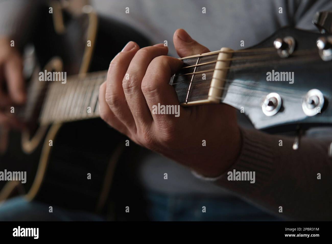 Playing the guitar. Strumming black acoustic guitar. Musician plays ...