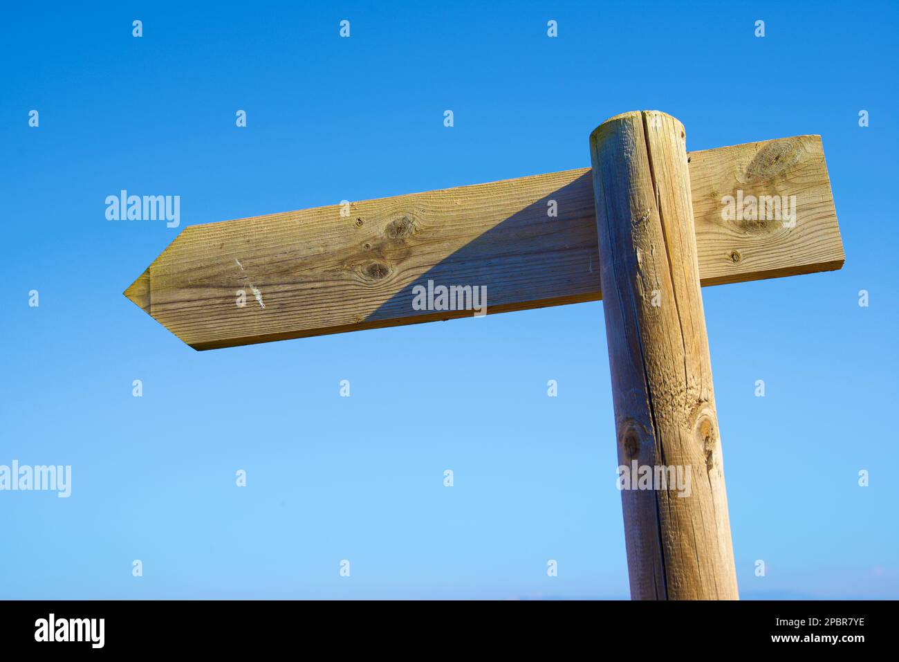Wooden arrow on a pole indicating direction and clear blue sky Stock ...