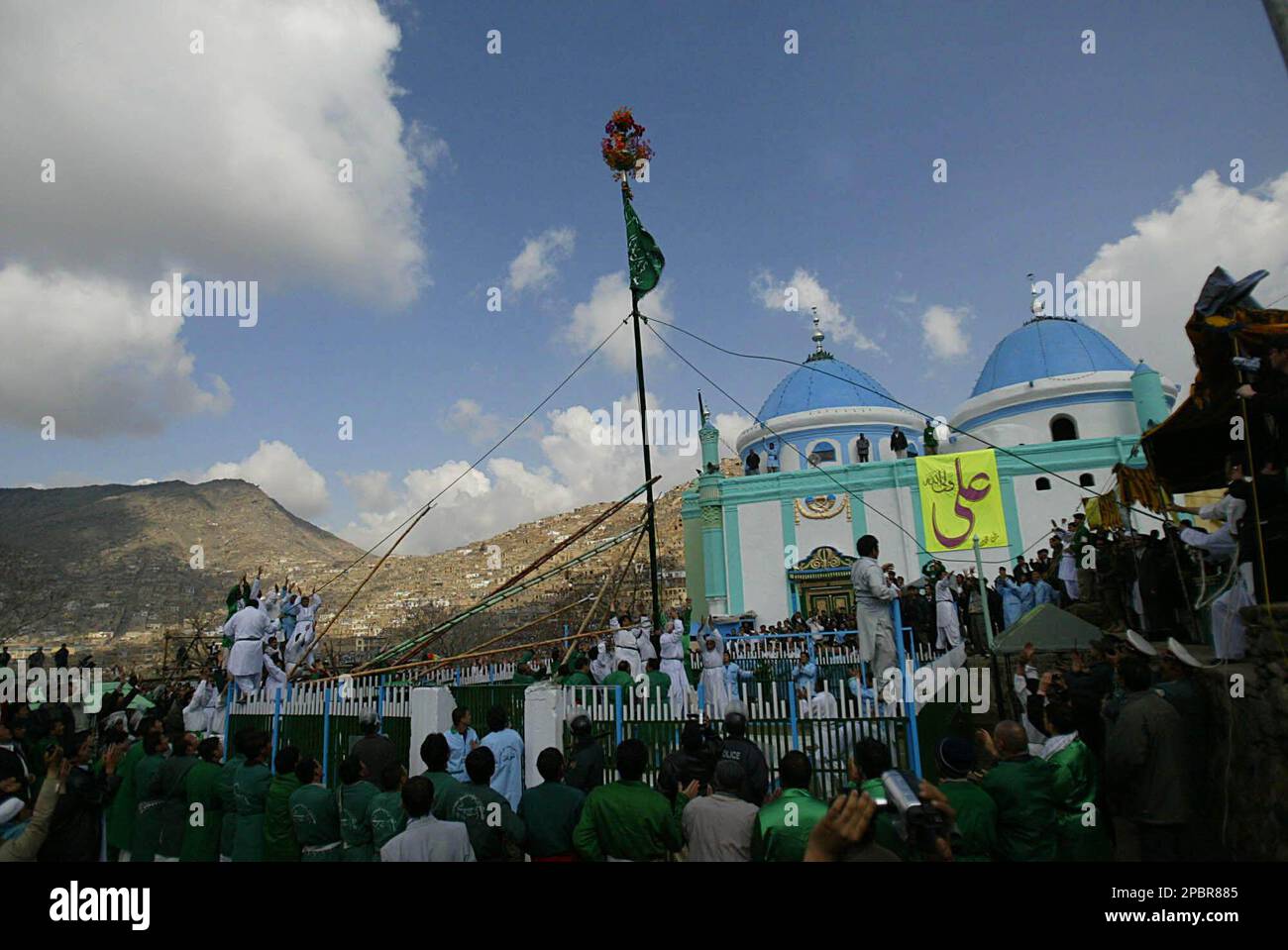 Afghan men hoist a holy mace on the occasion of Navroz, a new year ...