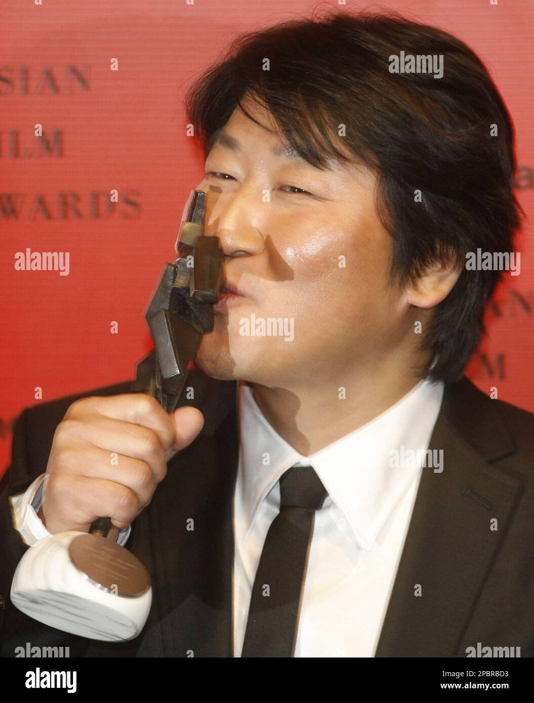 South Korean actor Song Kang Ho kisses his best actor award at the ...