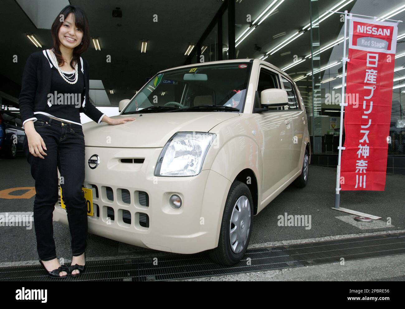 Eighteen-year-old Japanese hospital worker Ayano Sasao smiles by her Nissan Pino in front of a ...