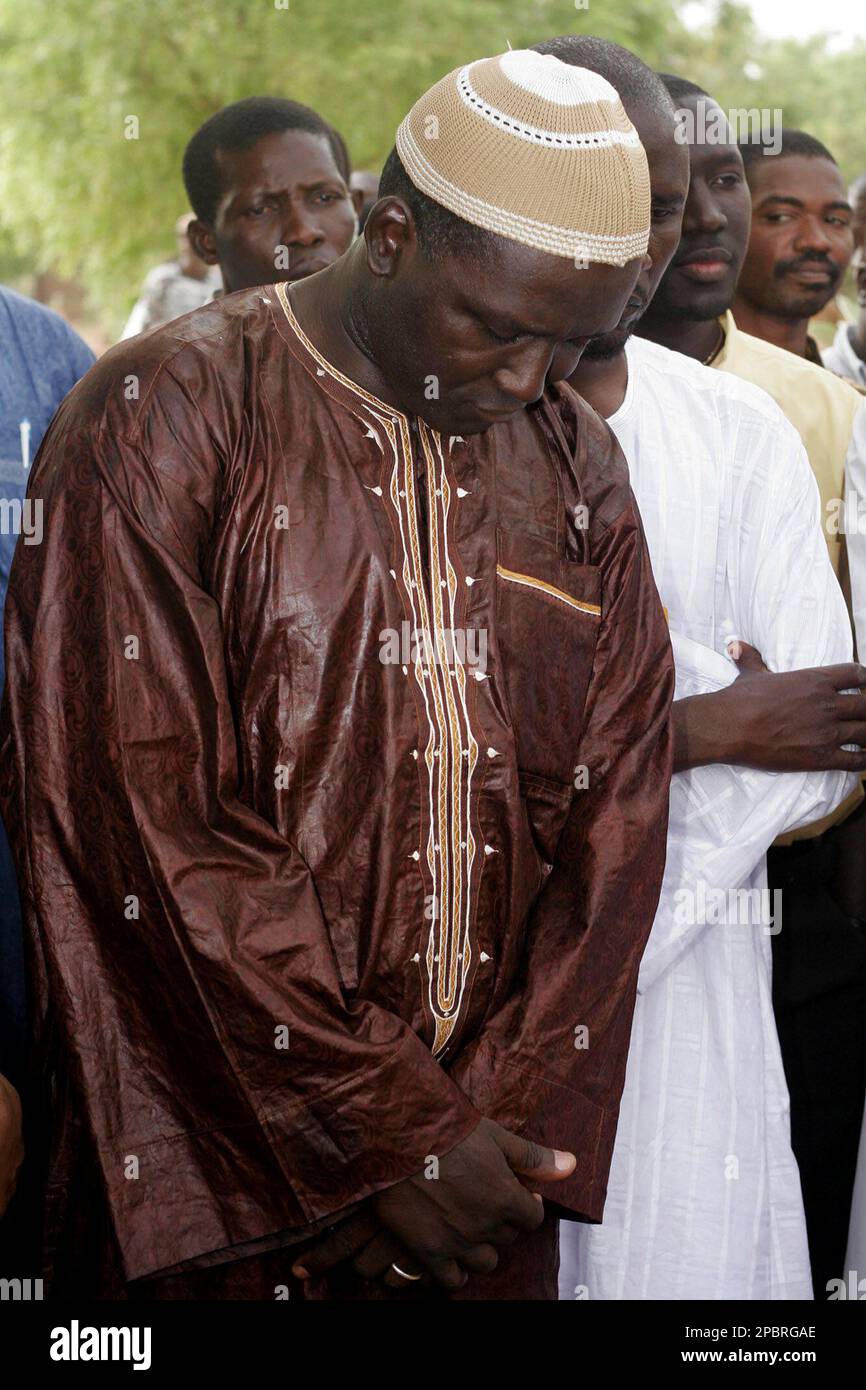 Mamadou Soumare bows his head as he stands with family and friends at ...