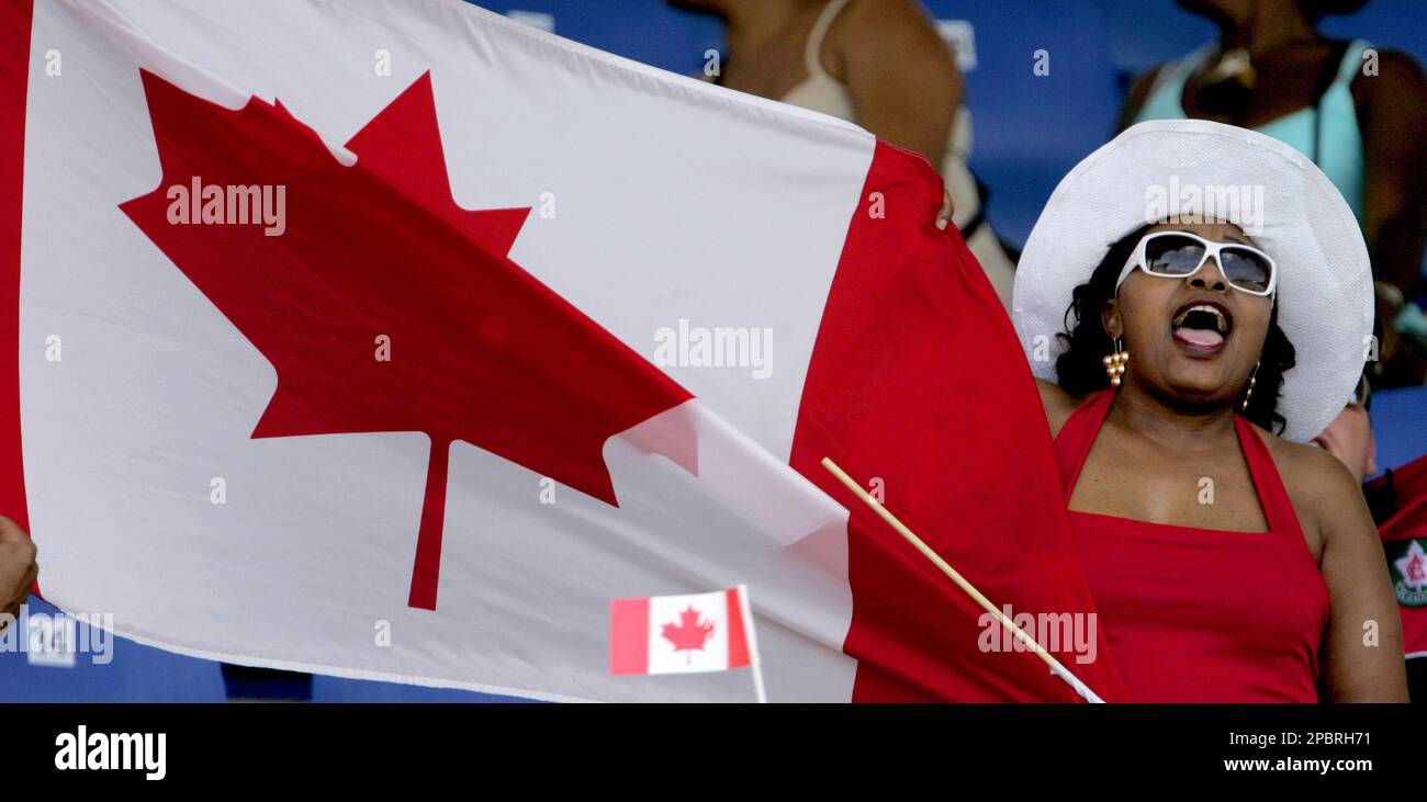 A Canada fan cheers from the stands as she holds Canadian flag during ...