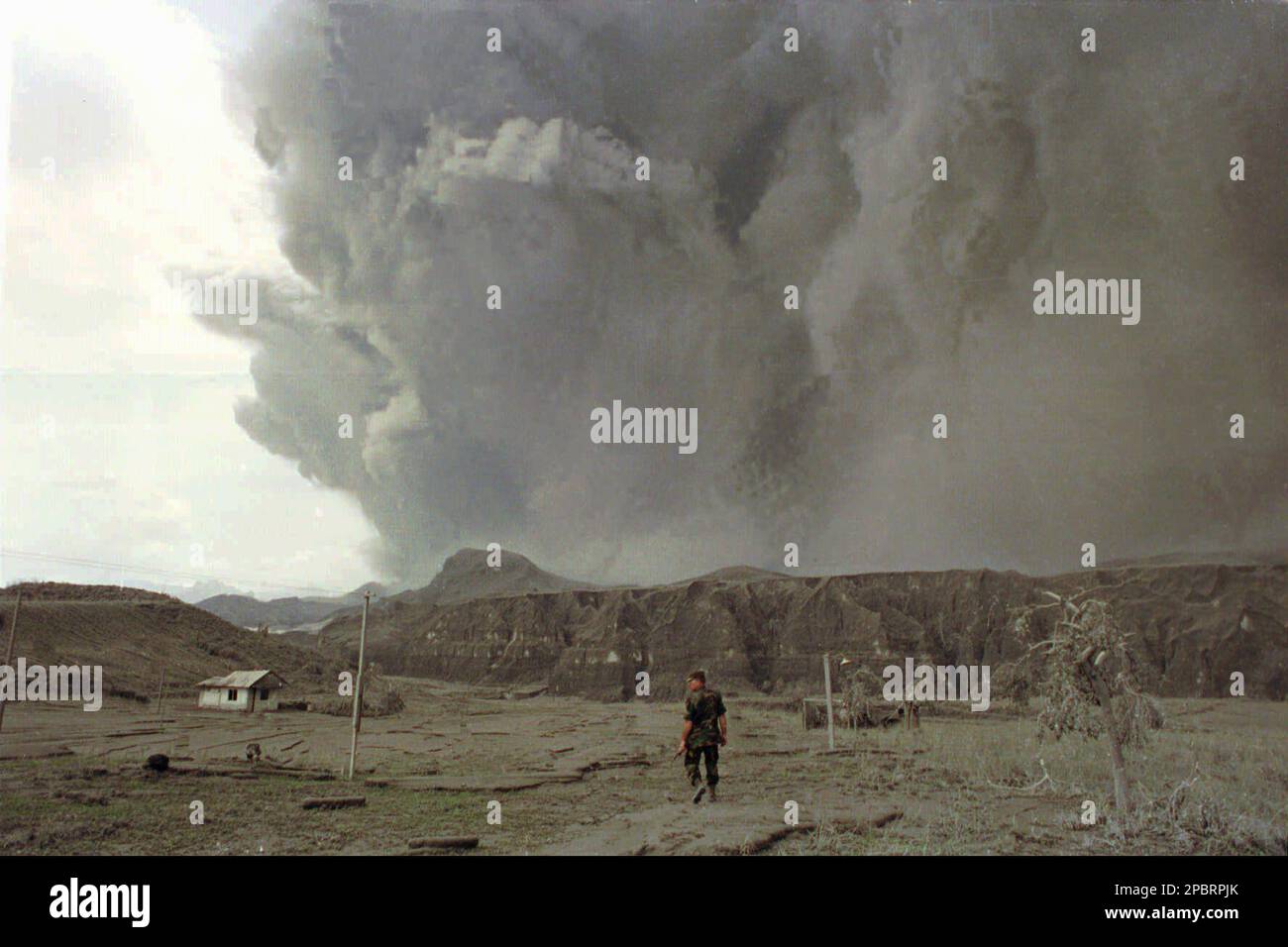 ** FILE ** A soldier walks towards an abandoned house as Mt. Pinatubo ...