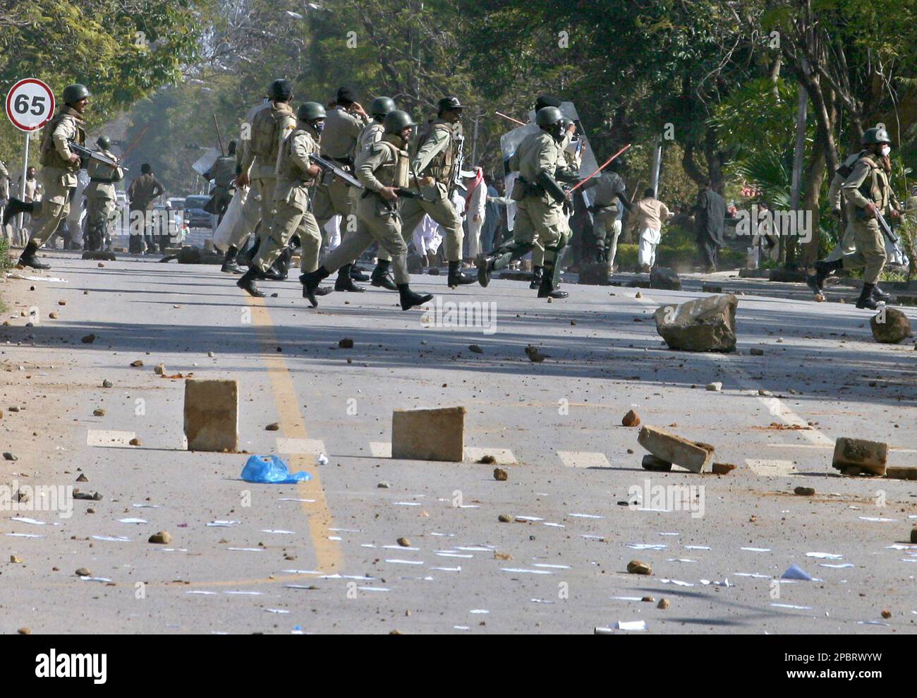 Pakistani paramilitary troops chase the protestors during an anti ...