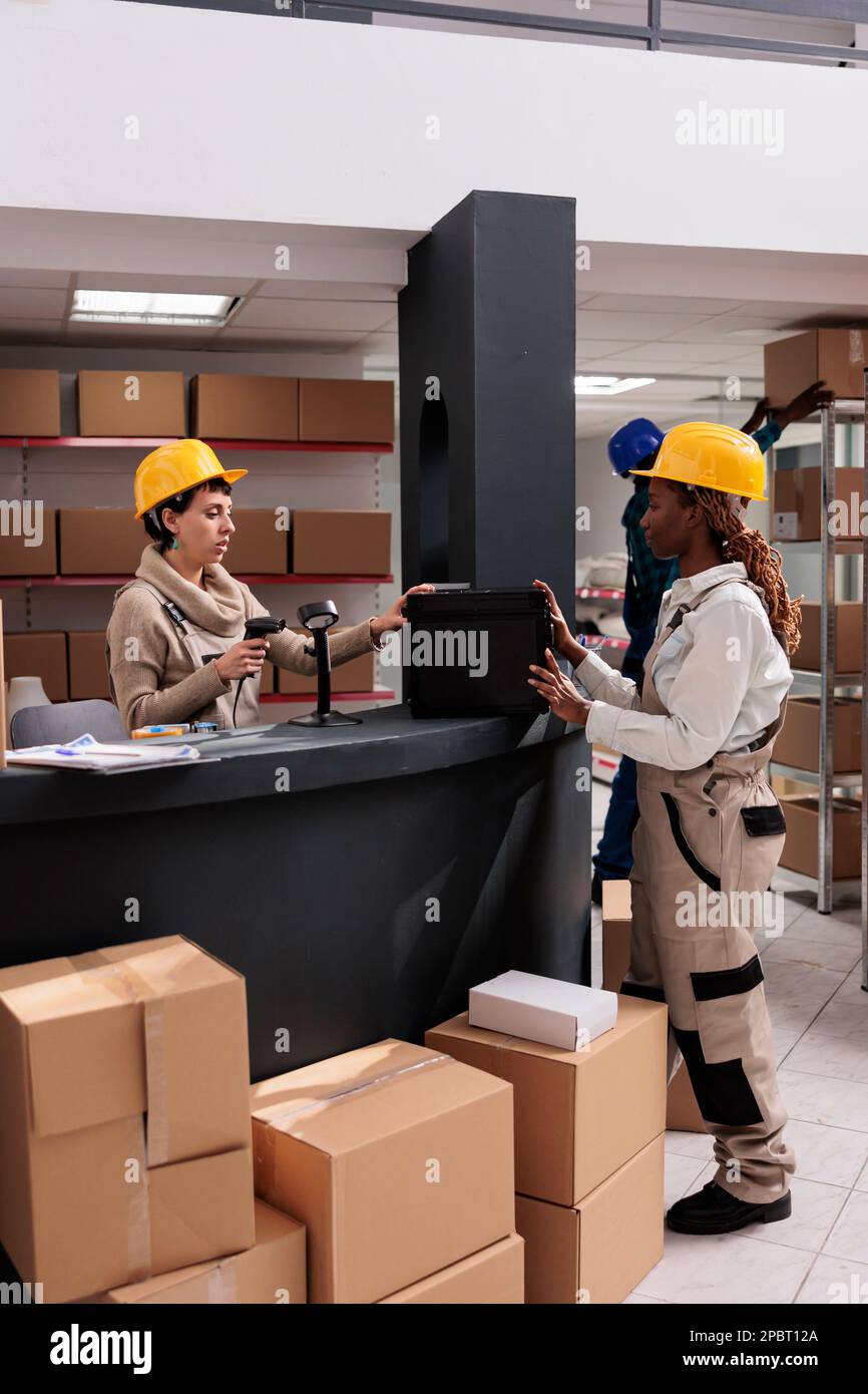 Warehouse manager scanning black case at counter desk and doing ...